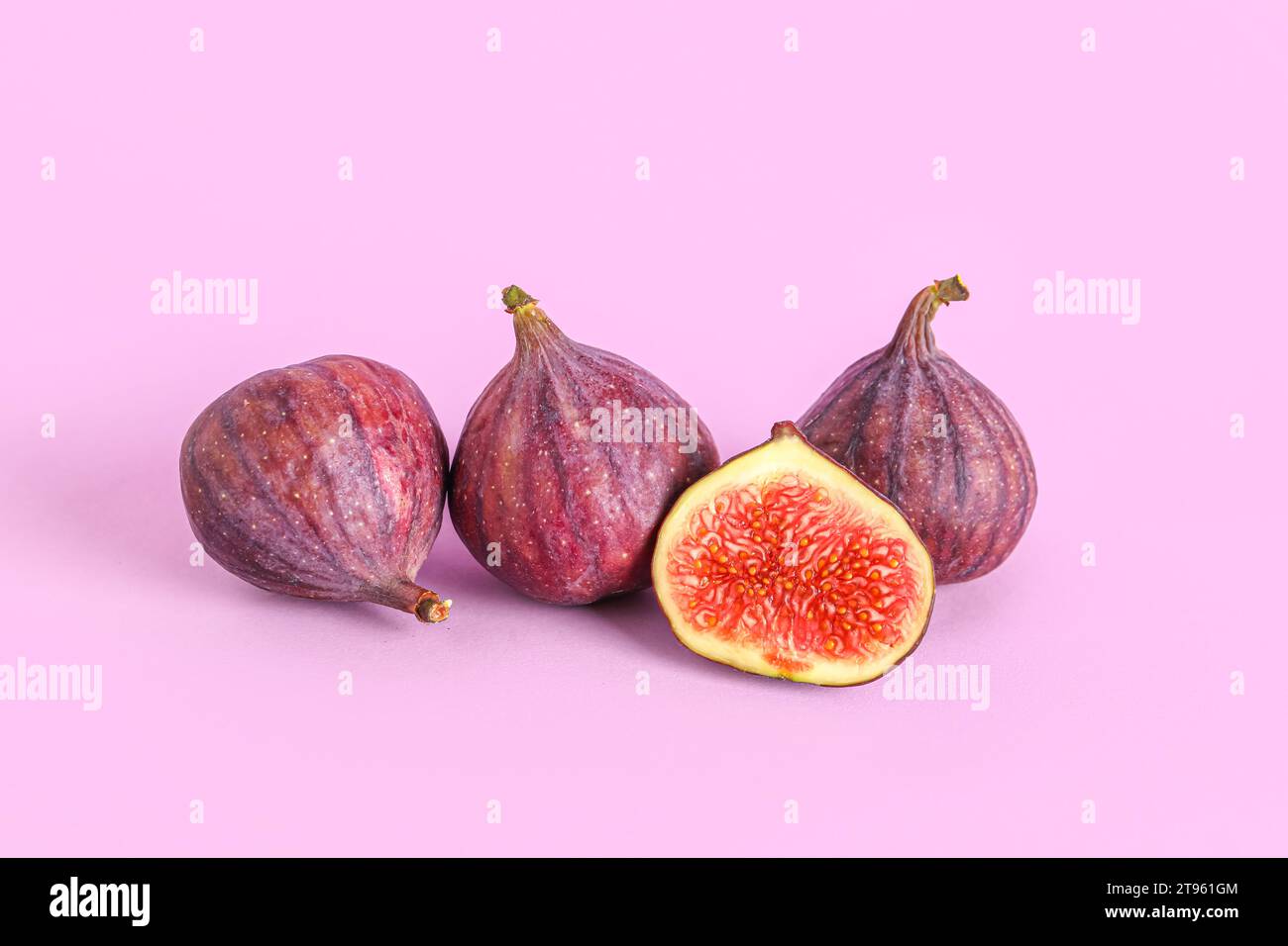 Fresh juicy cut figs on lilac background Stock Photo - Alamy