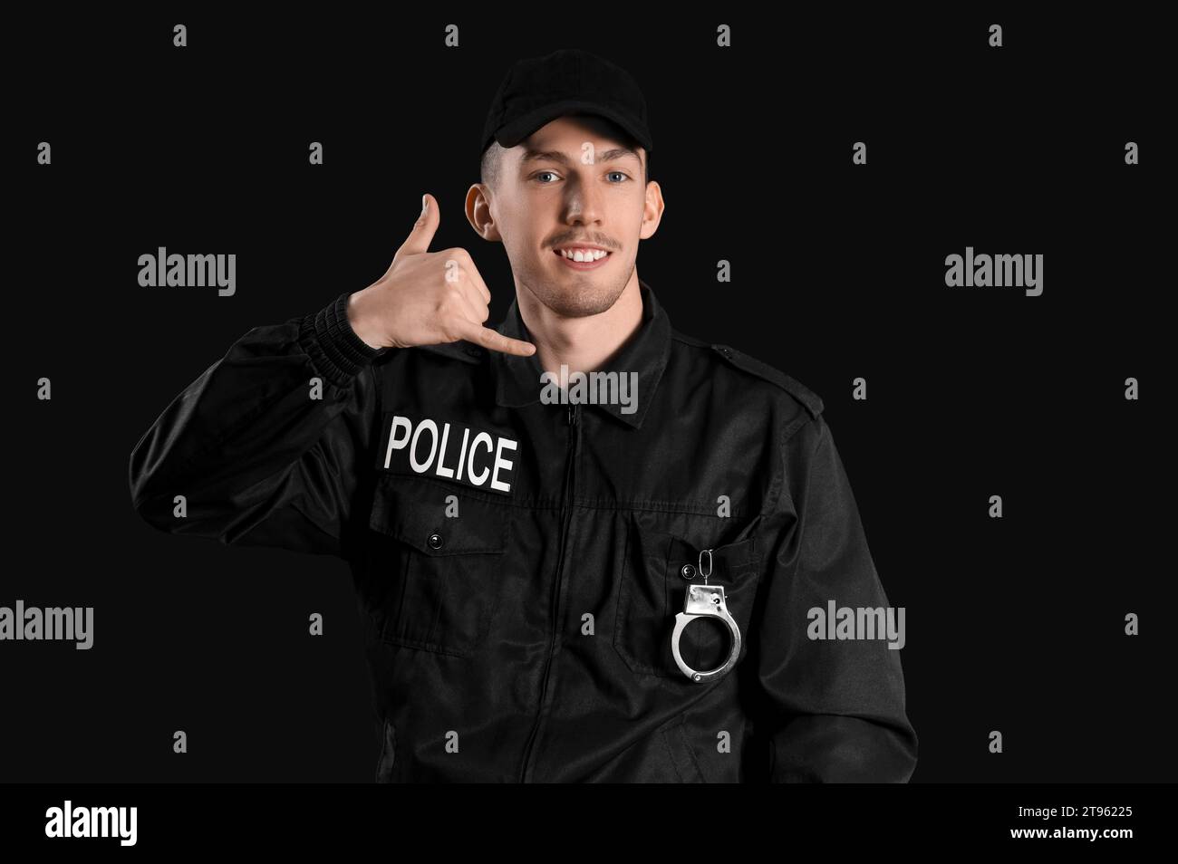 Young police officer showing "call me" gesture on dark background Stock ...