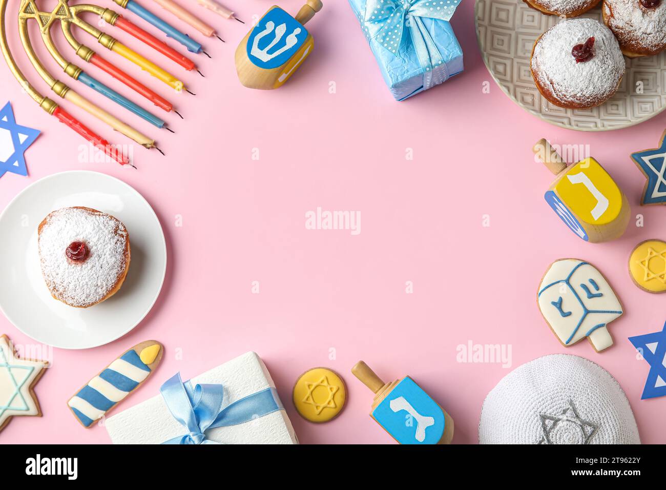 Frame made of kipa, dreidels, menorah, plates with donuts and gift ...