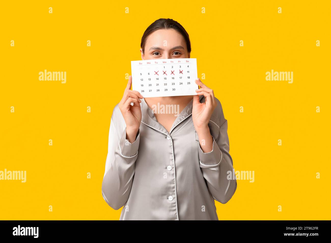Beautiful young woman holding calendar with marked days of menstruation ...