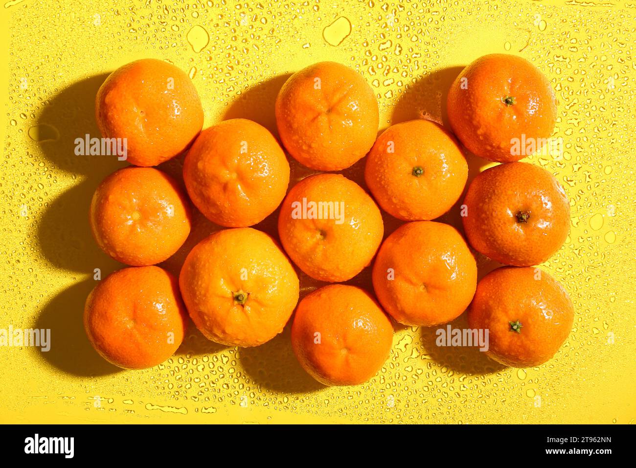 Sweet mandarins in water on yellow background Stock Photo - Alamy