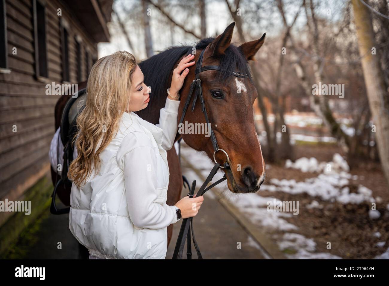 Young beautiful rider woman blonde with long hair in white clothes ...