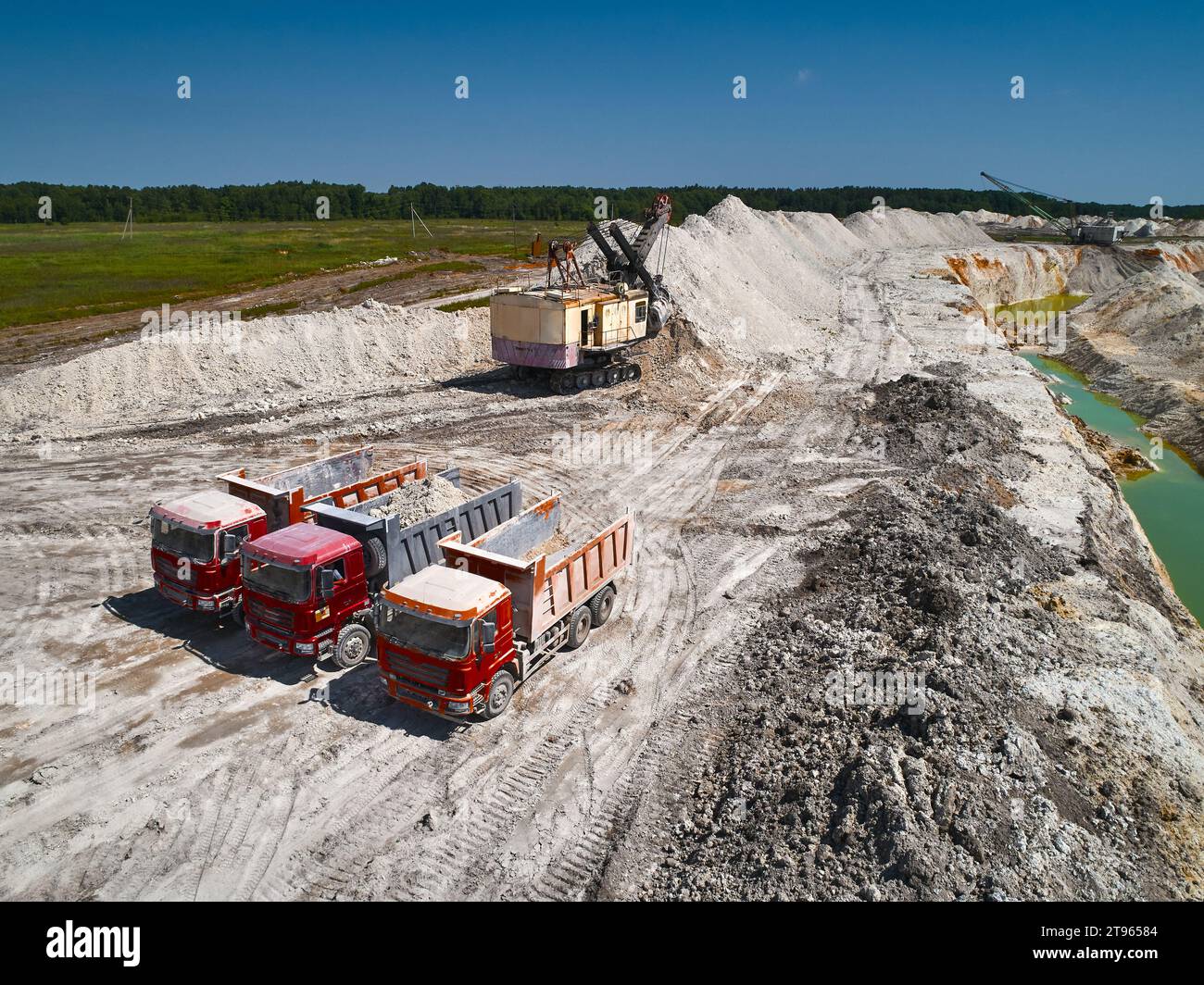 Red tipper trucks and shovel mining excavator in mining quarry Stock ...