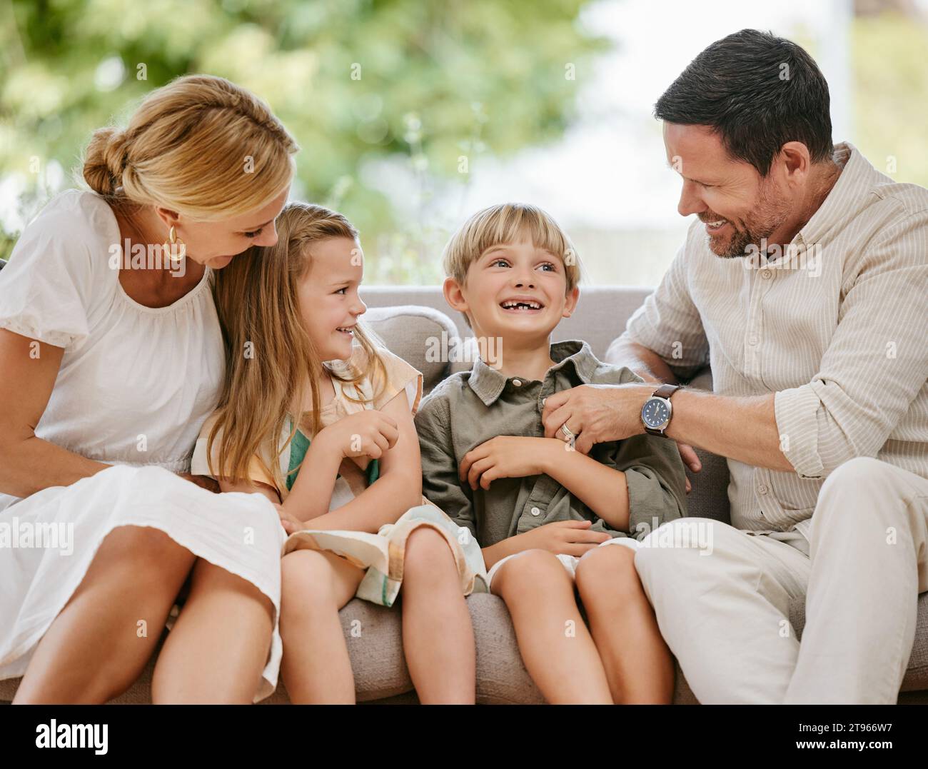 Family, tickle and play on sofa, laughing and bonding at home, fun and ...