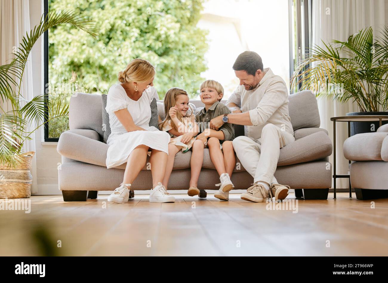 Family, tickle and play on couch, laughing and bonding at home, fun and ...