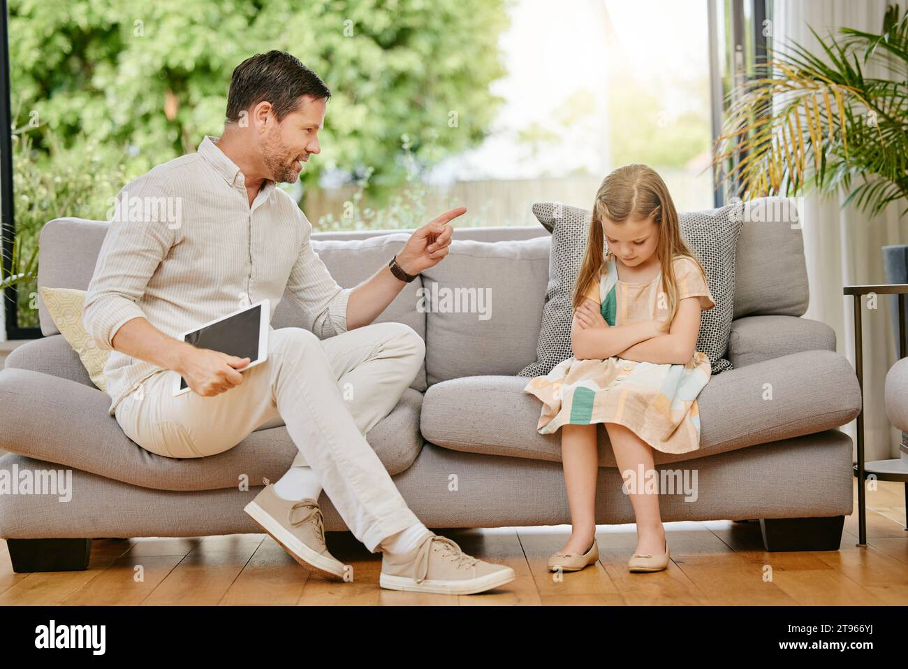 Parent, child and tablet with discipline on a sofa in the living room ...