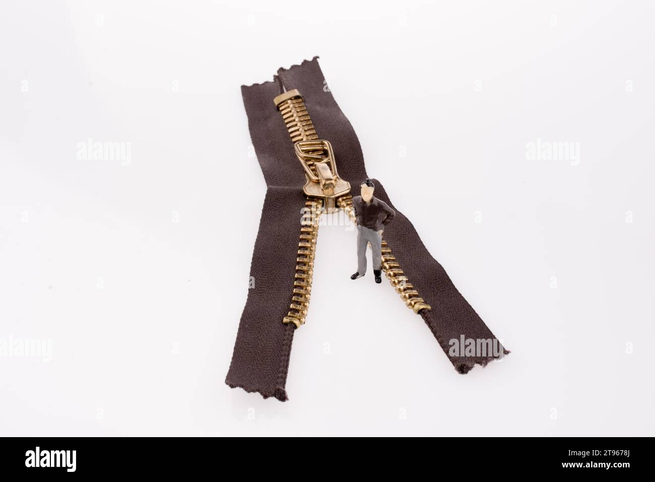 Close up or macro of a brown zipper and a little model man on white ...
