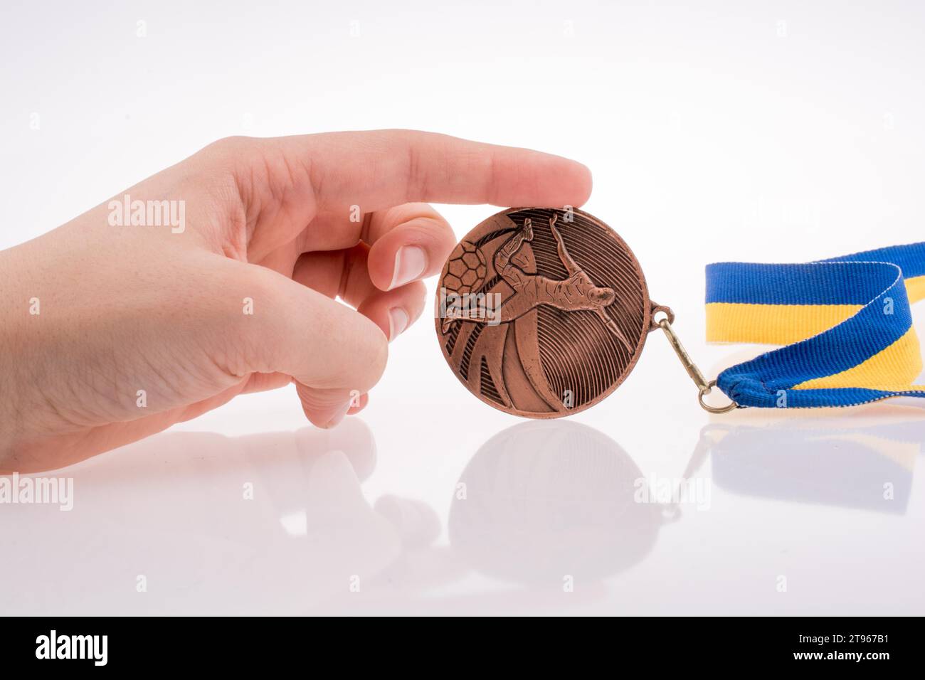 Hand holding a medal with blue and yellow ribbon Stock Photo - Alamy