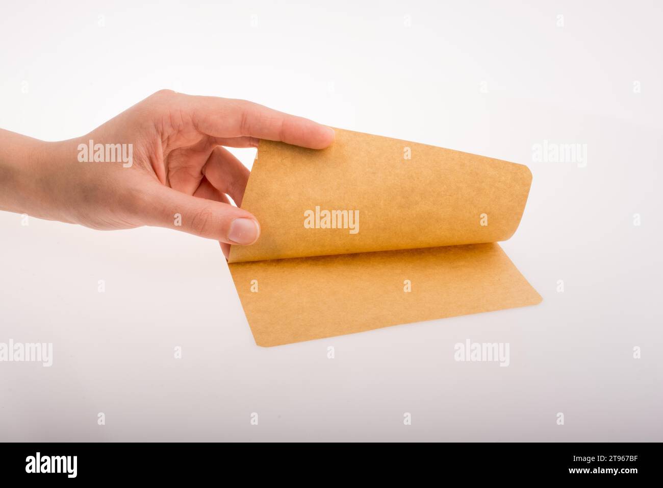 Hand holding a sheet of paper on a white background Stock Photo - Alamy