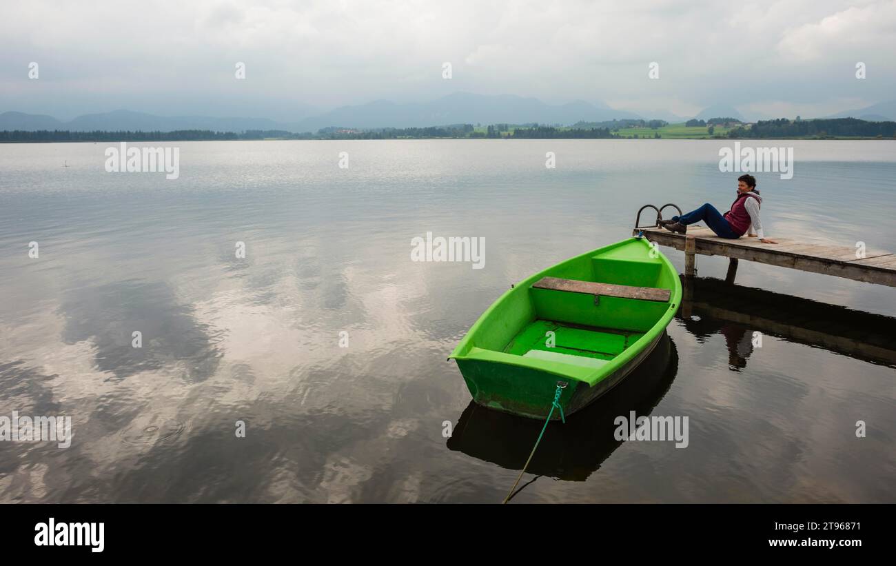 Woman 50+, wooden jetty, green rowing boat, Hopfensee, Hopfen am See ...