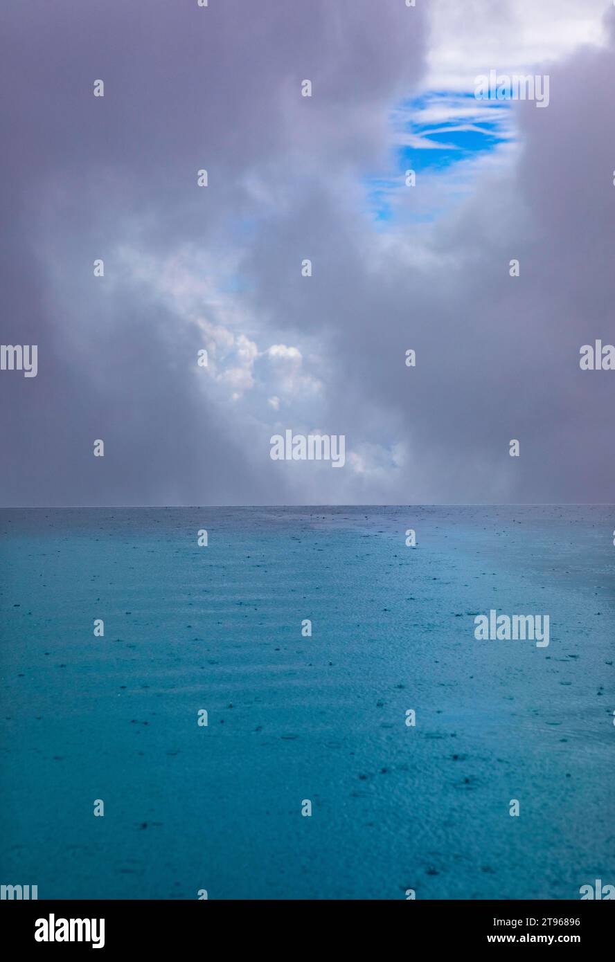 Rippled water surface during rain in swimming pool with dramatic cloudy ...