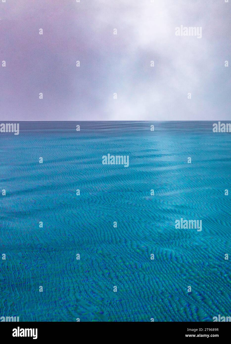 Rippled water surface during rain in swimming pool with dramatic cloudy ...