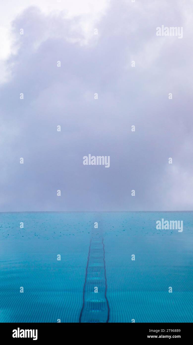 Rippled water surface during rain in swimming pool with dramatic cloudy ...