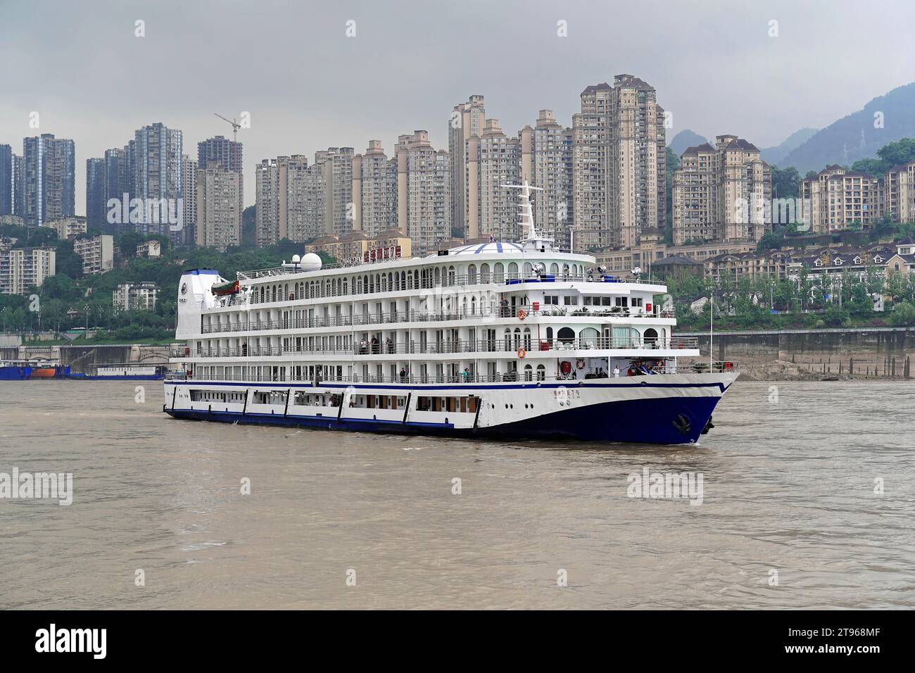 Cruise ship on the Yangtze River against a backdrop of skyscrapers ...