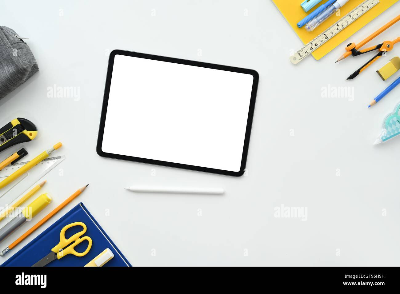 Digital tablet with empty screen and school supplies on white ...