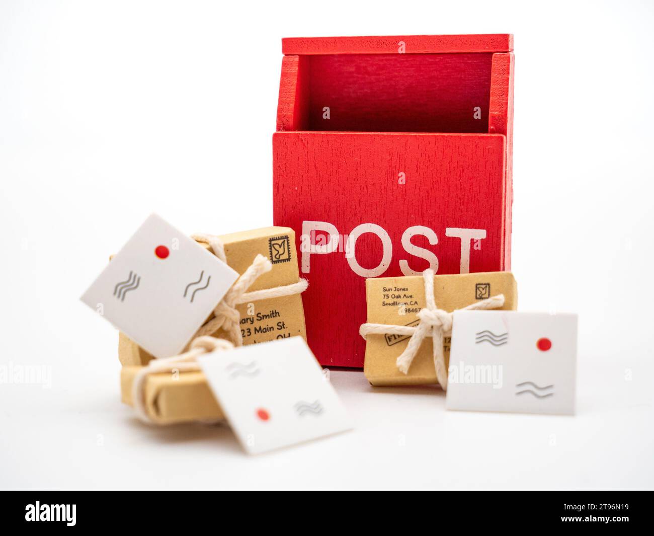 A red mail box with envelopes scattered around its base against a plain ...