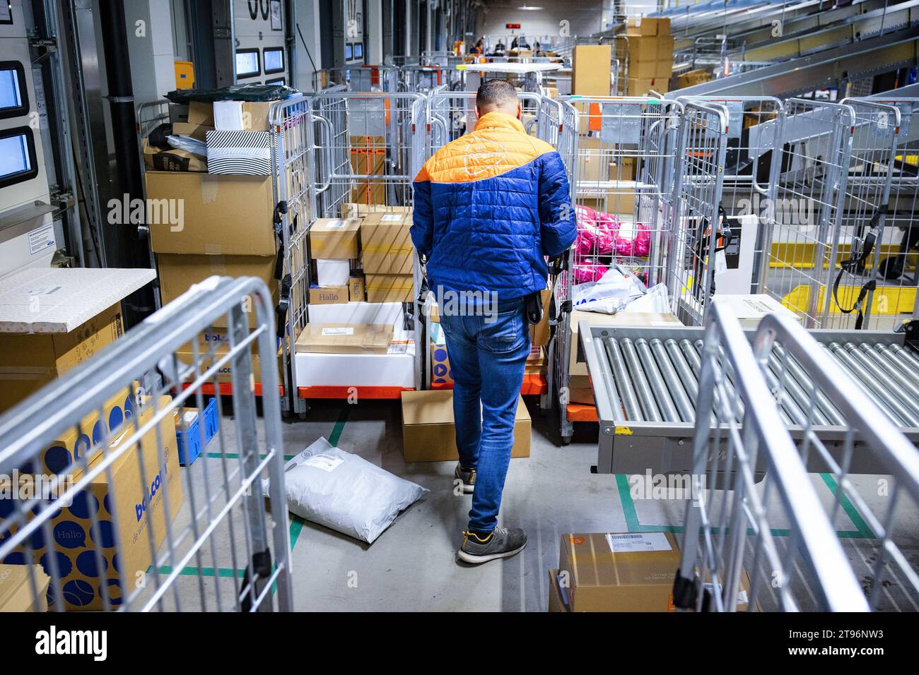 WESTZAAN - PostNL employees at work in a parcel sorting center. In the ...