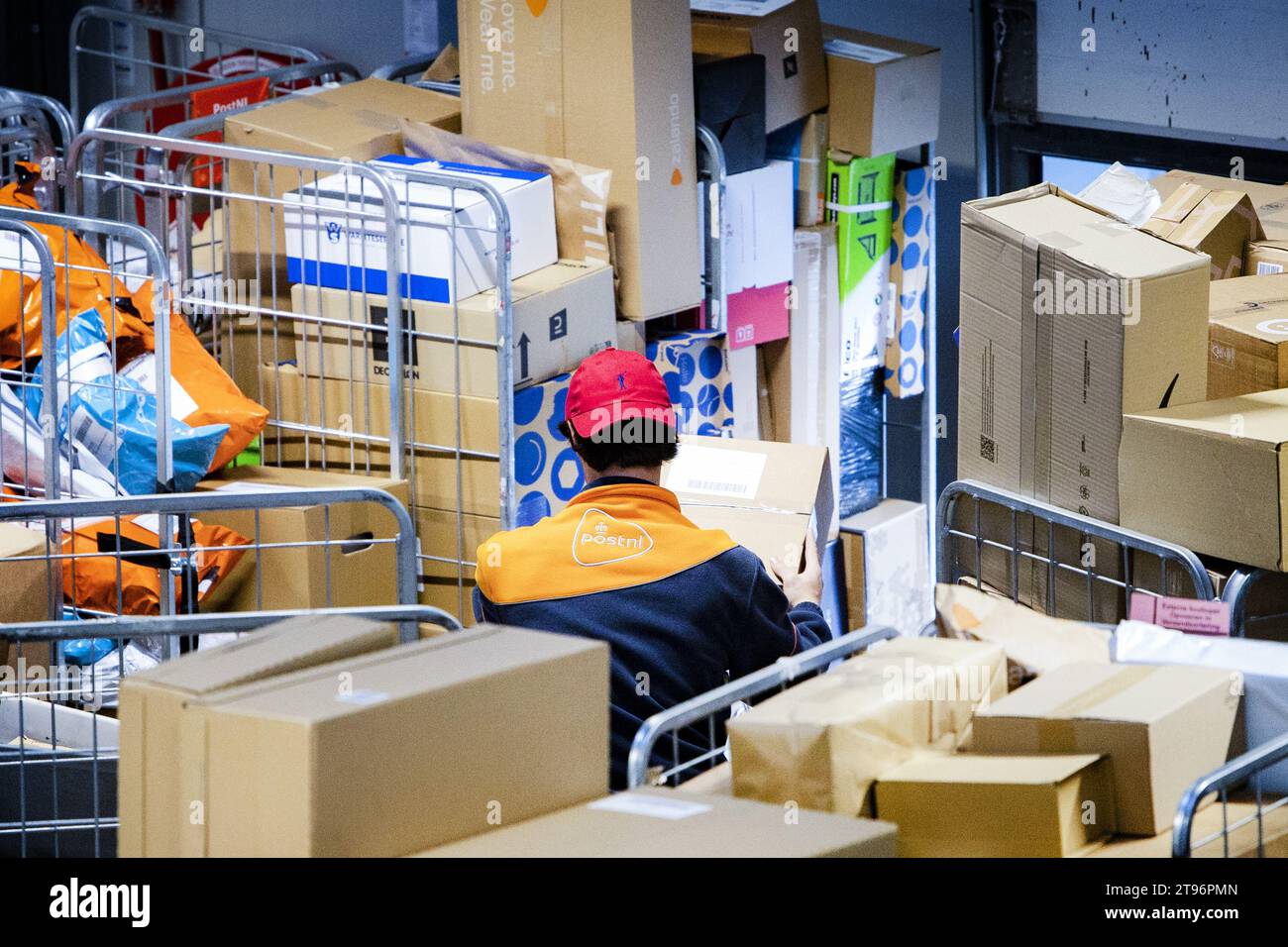 WESTZAAN - PostNL employees at work in a parcel sorting center. In the ...