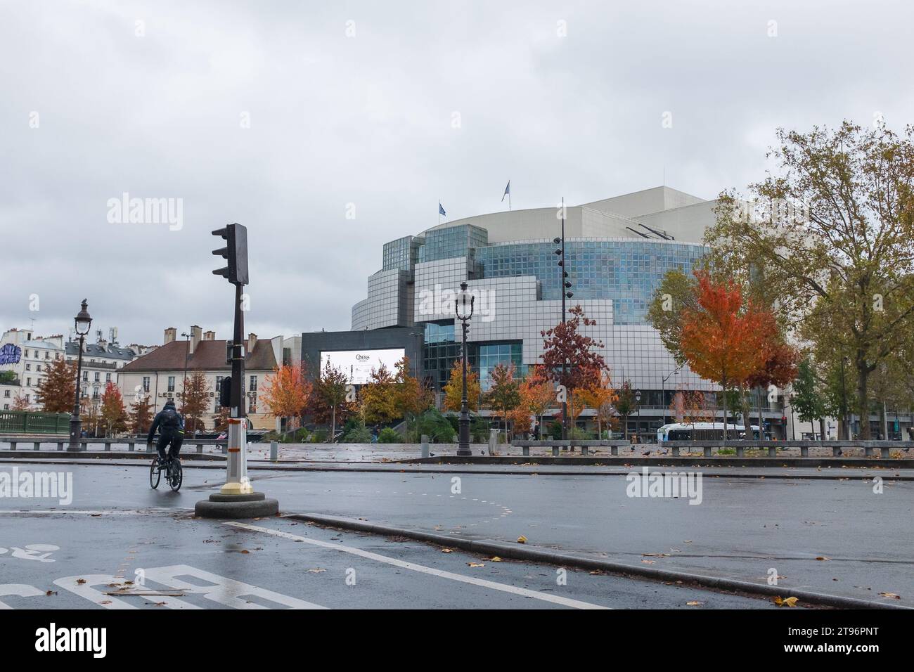 Paris, France, 2023. Place de la Bastille, a lone cyclist is riding in the bike lane, with the ...