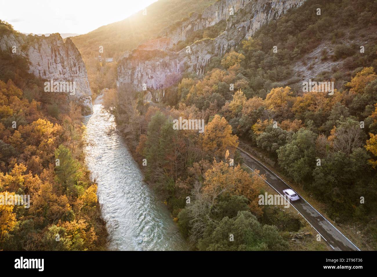 Aerial view of a shimmering river cutting through an autumn forest ...
