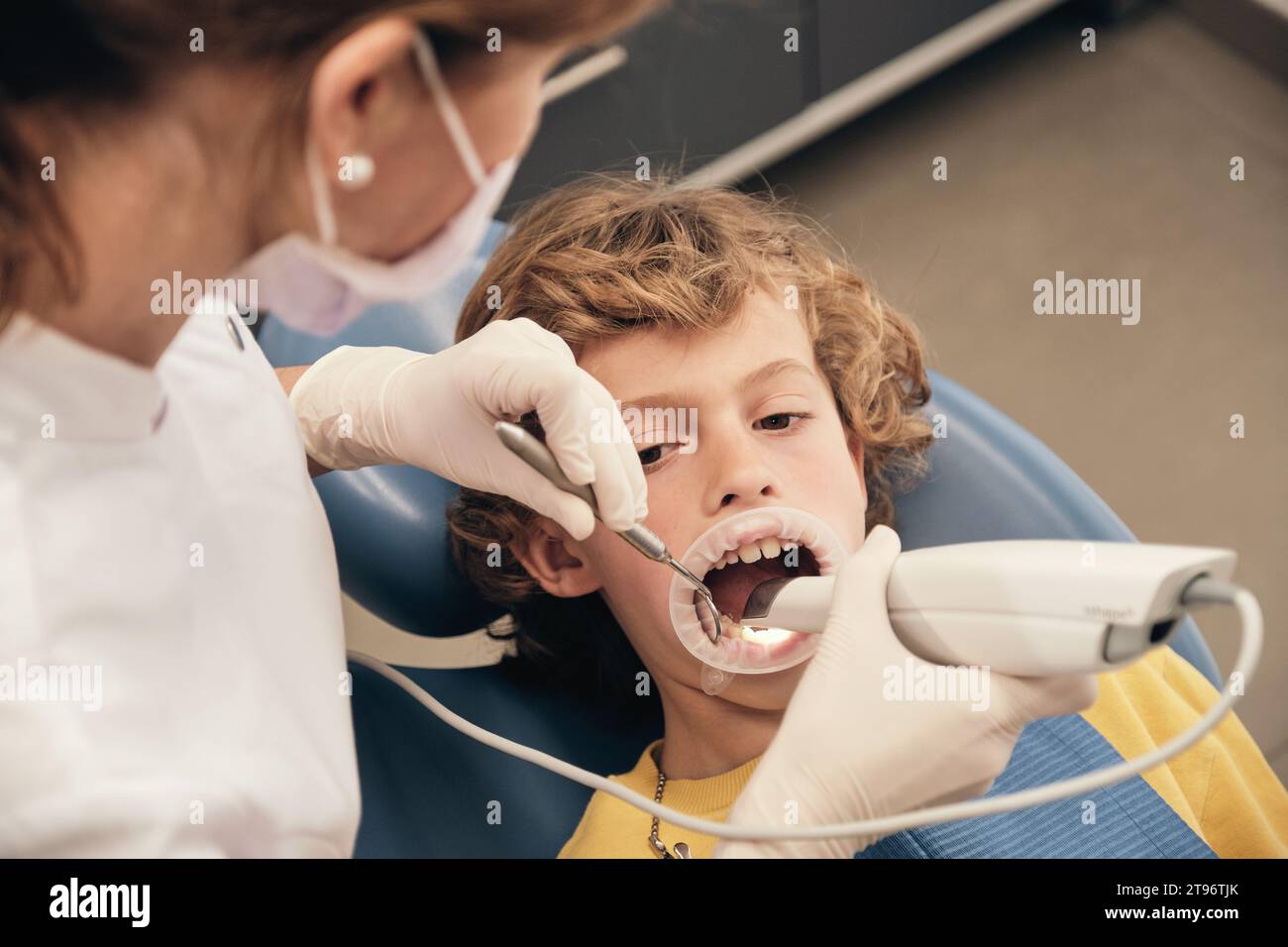 From above of crop anonymous female dentist applying intraoral scanner ...
