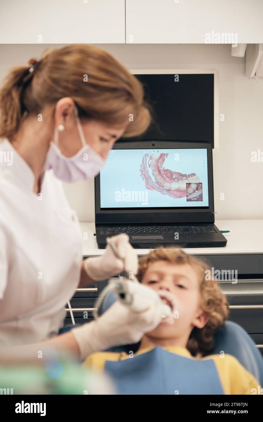 Side view of female dentist in white uniform and mask and gloves ...