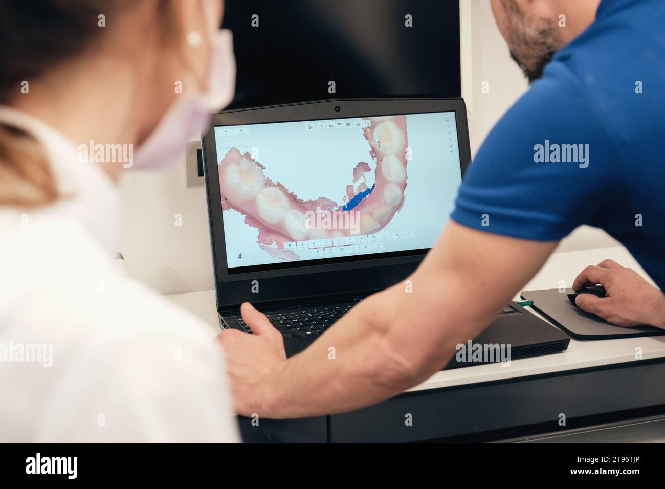 Crop anonymous professional dentists examining 3D teeth scan on laptop ...