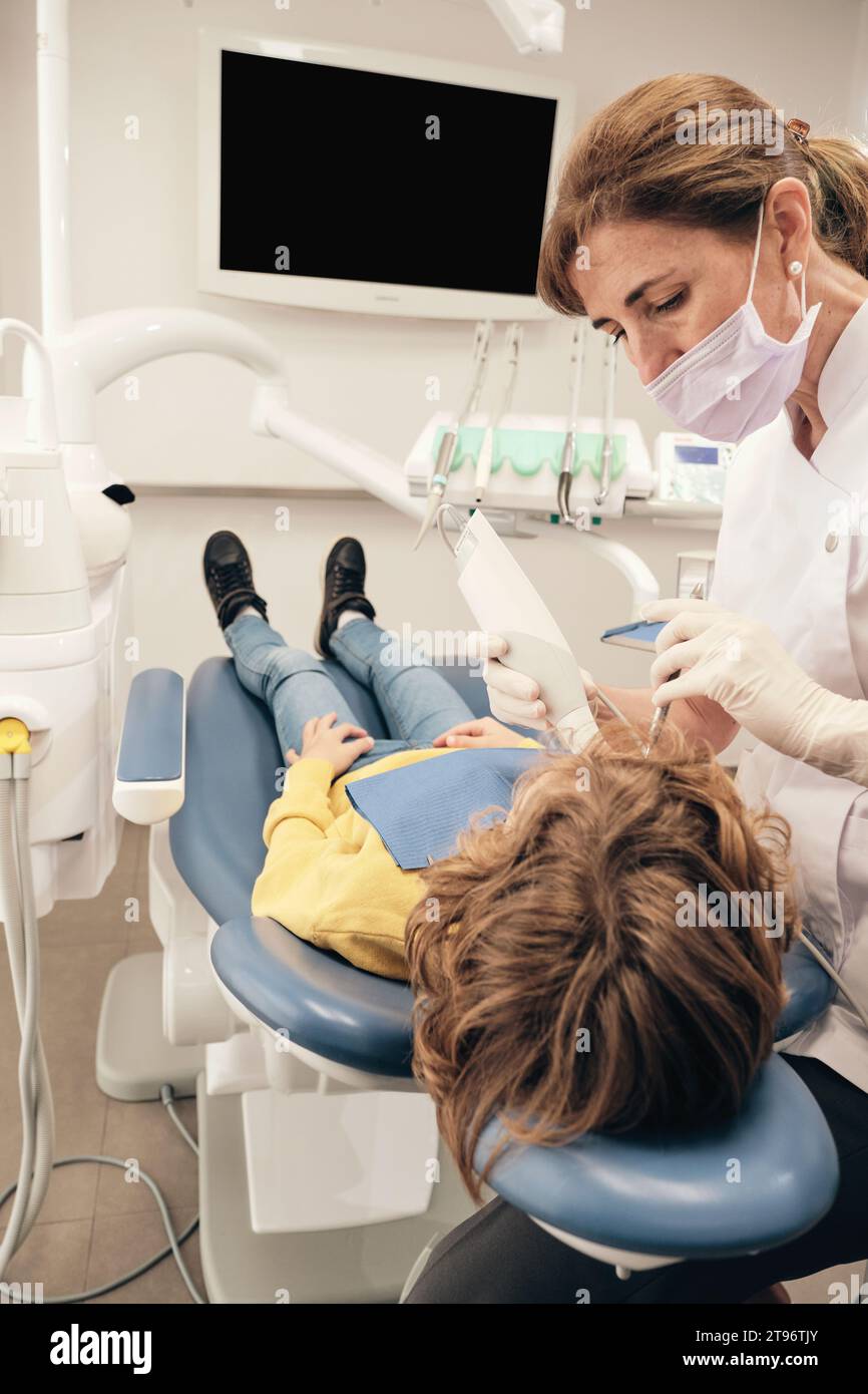 Professional female dentist using dental 3D scanner to scan teeth of ...