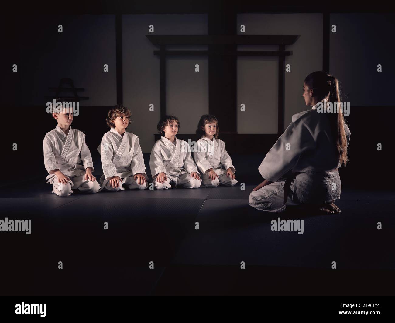 Krav Maga female instructor sitting on knees in front of group of ...