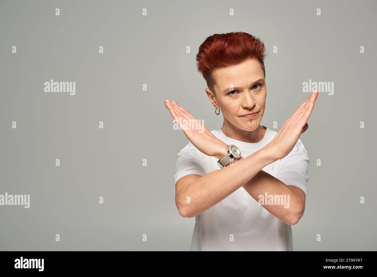 strict and serious bigender person with red hair showing stop gesture ...