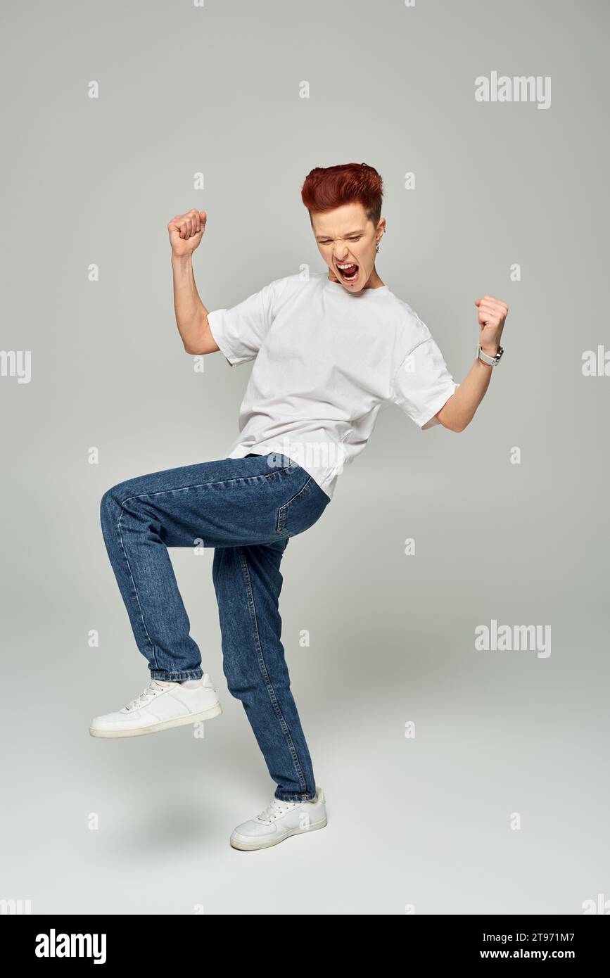 excited queer person in white t-shirt and jeans shouting and gesturing ...