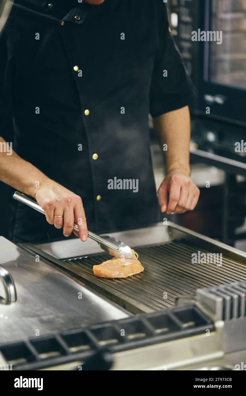 Chef in the Kitchen of the Restaurant prepares dishes for serving to ...