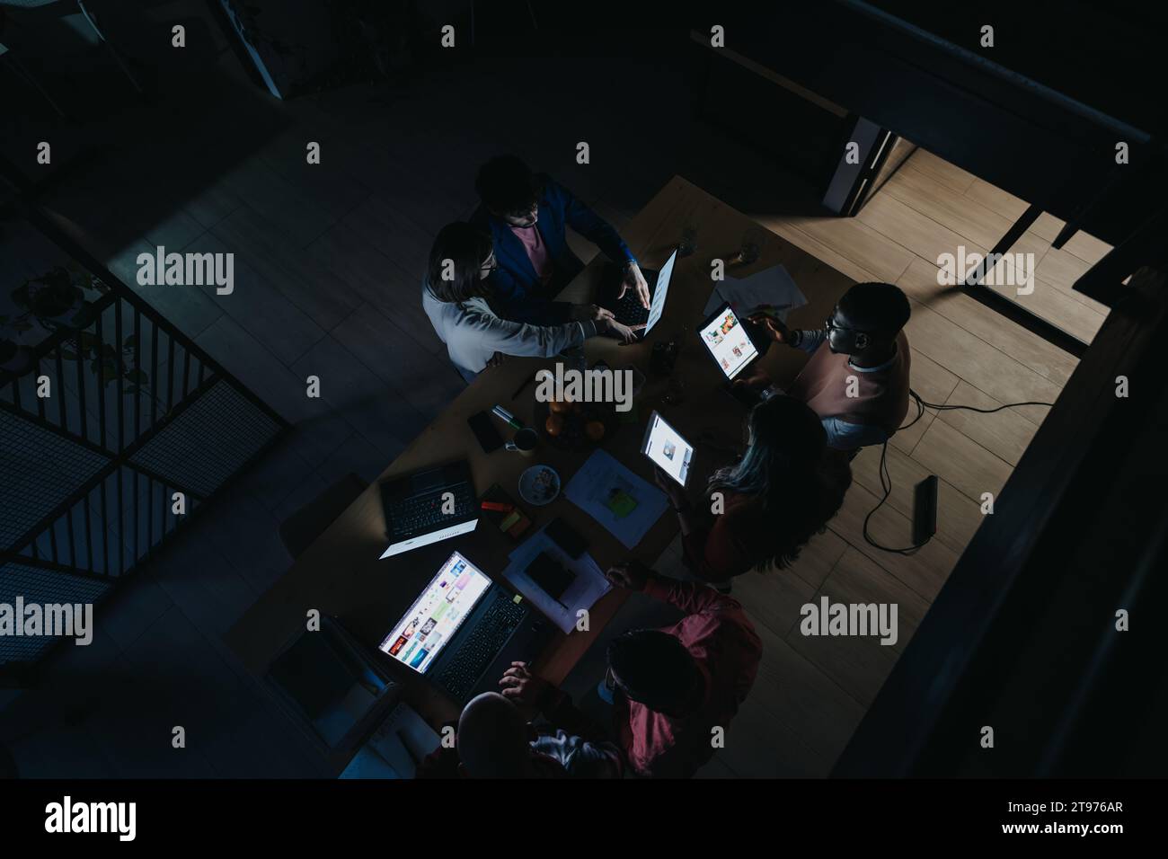 Diverse team working late, collaborating on project details for success ...