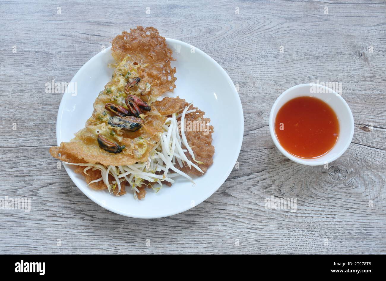 crispy fried egg and flour stuffed mussel with bean sprout on plate ...