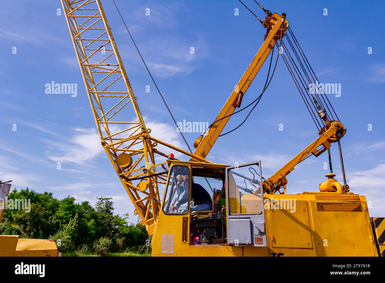 Side view on open cabin of the yellow mobile crane with erected long ...