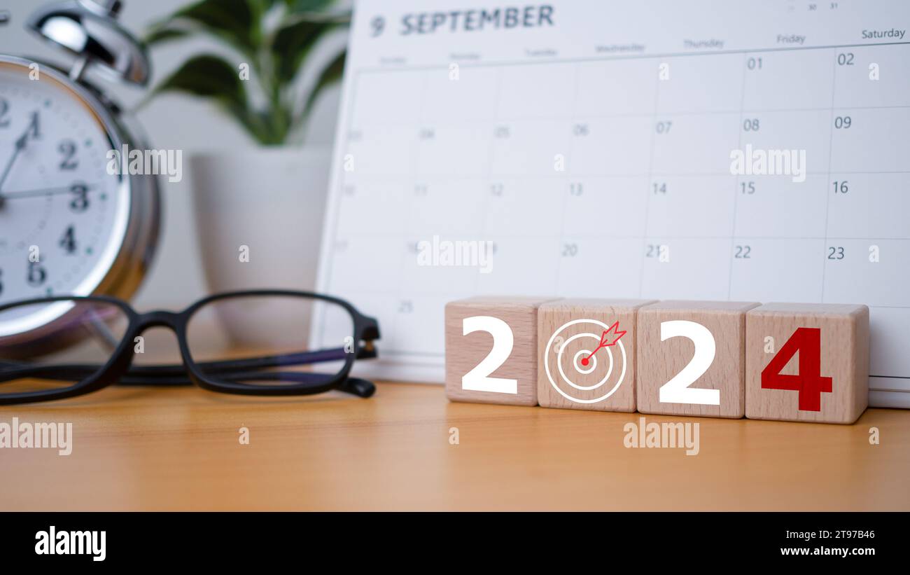 Wooden blocks with letters 2024 with calendar and alarm clock on wooden ...