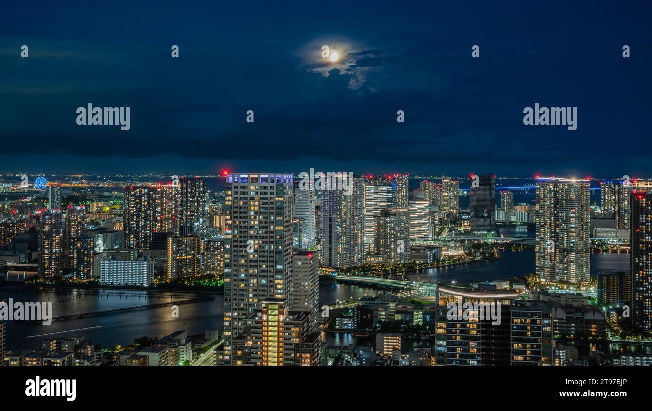 Tokyo skyline at night with moon Stock Photo - Alamy