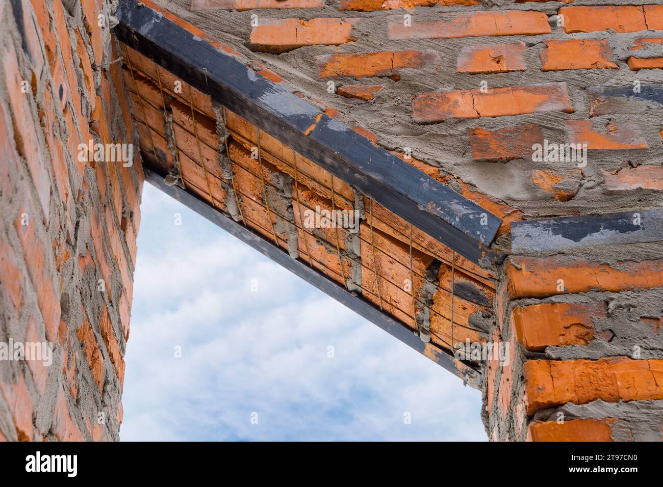 Window, door metal lintel with iron bar on brick unfinished building ...