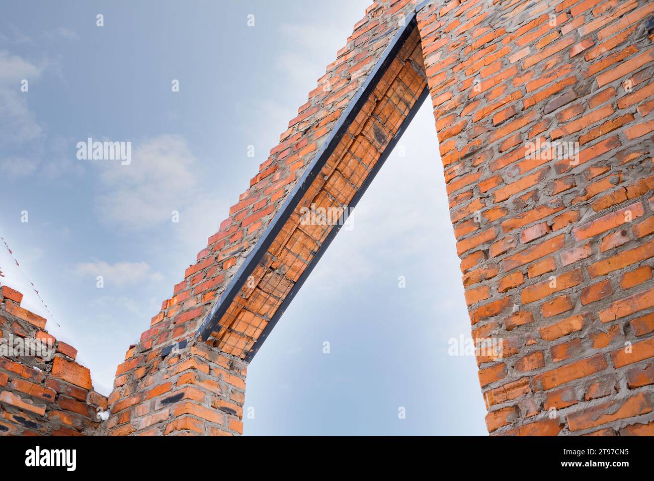 Window, door metal lintel with iron bar on brick unfinished building ...
