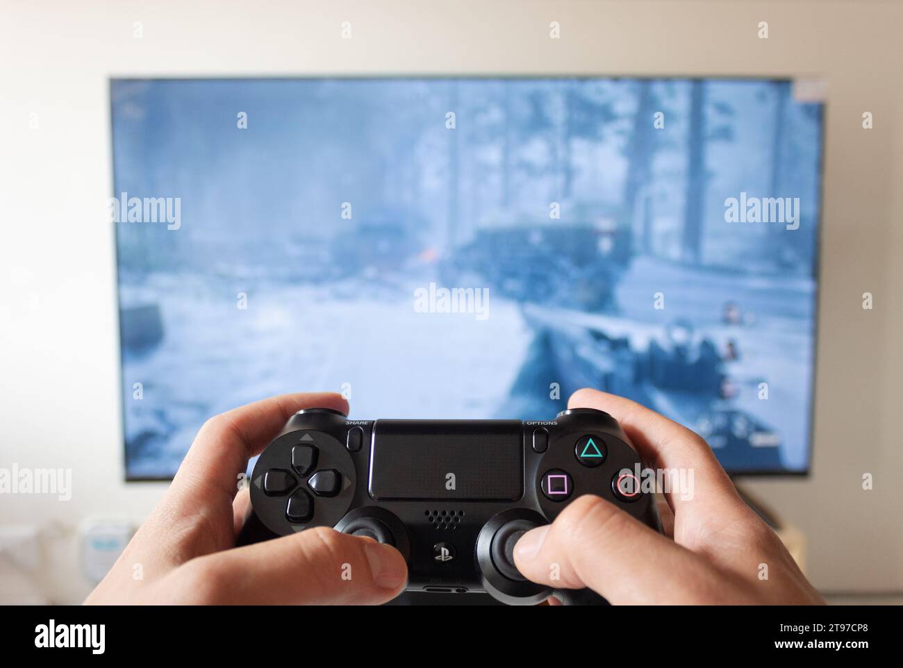 A male hand holding a play station 4 controller with first person video ...