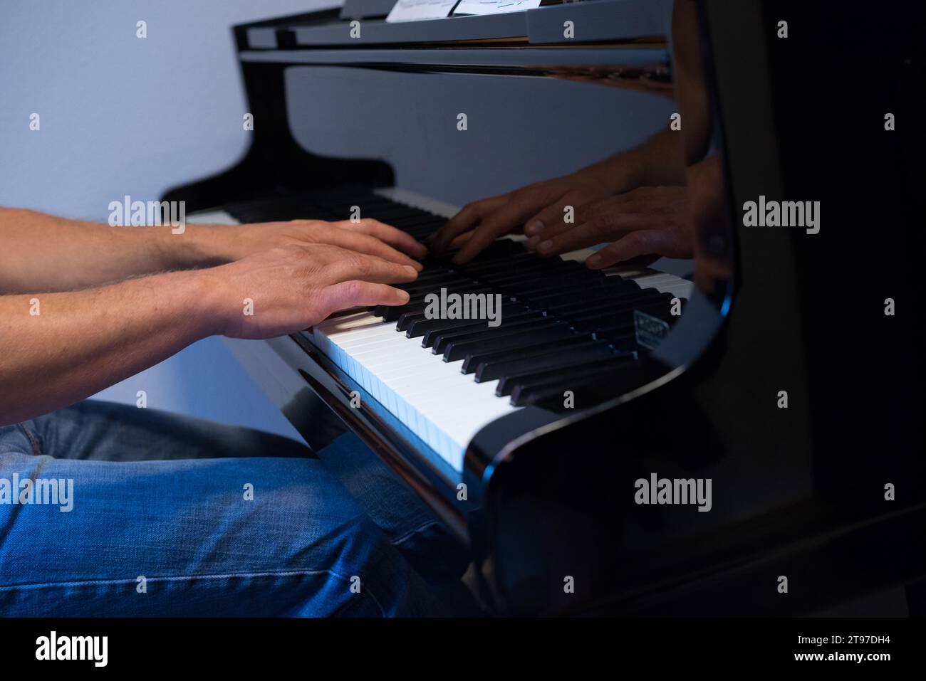 Human hands playing the keys notes and chords on a classic black piano ...
