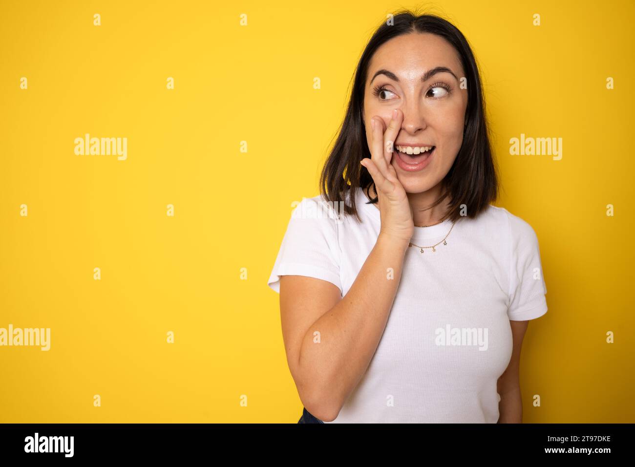 A close up portrait of a young pretty woman telling secret information ...