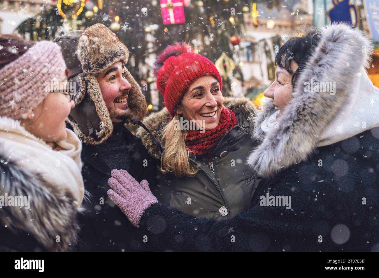 Group of friends sharing joyful moments in a snowy christmas market ...