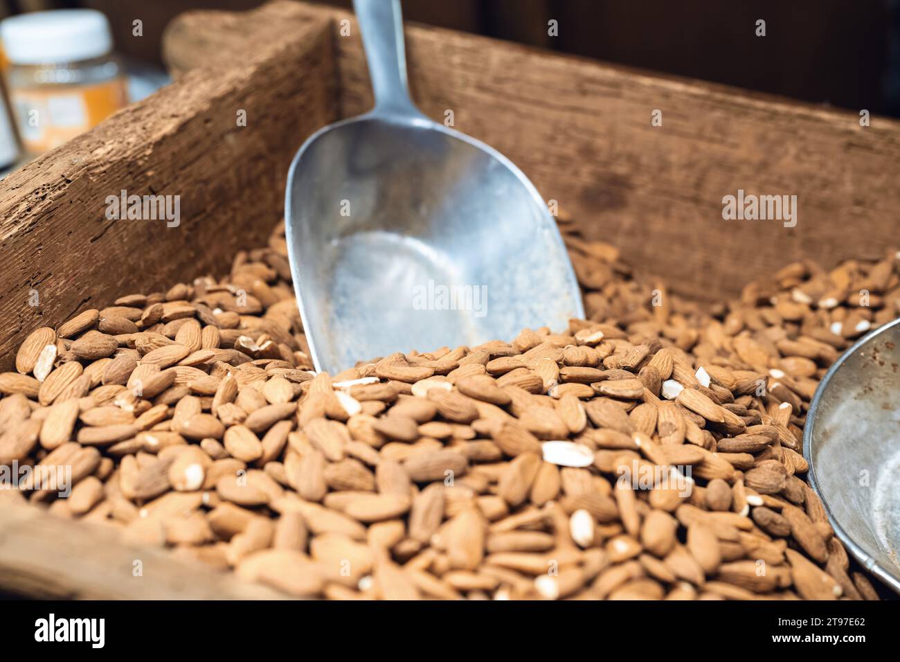 Almonds in a wooden scoop in a rustic wooden box at a Christmas market ...