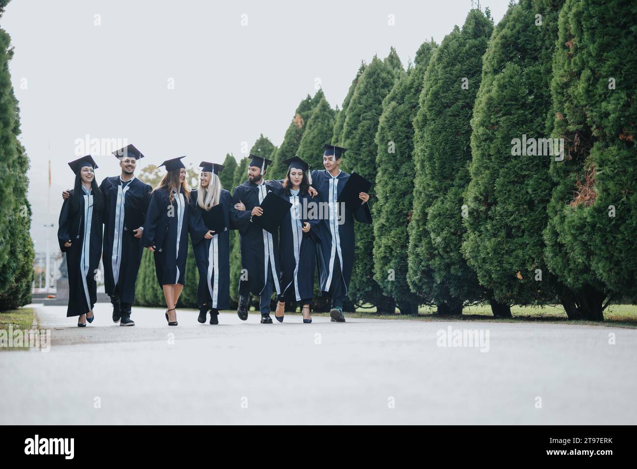 University students in graduation gowns celebrate their success in a ...