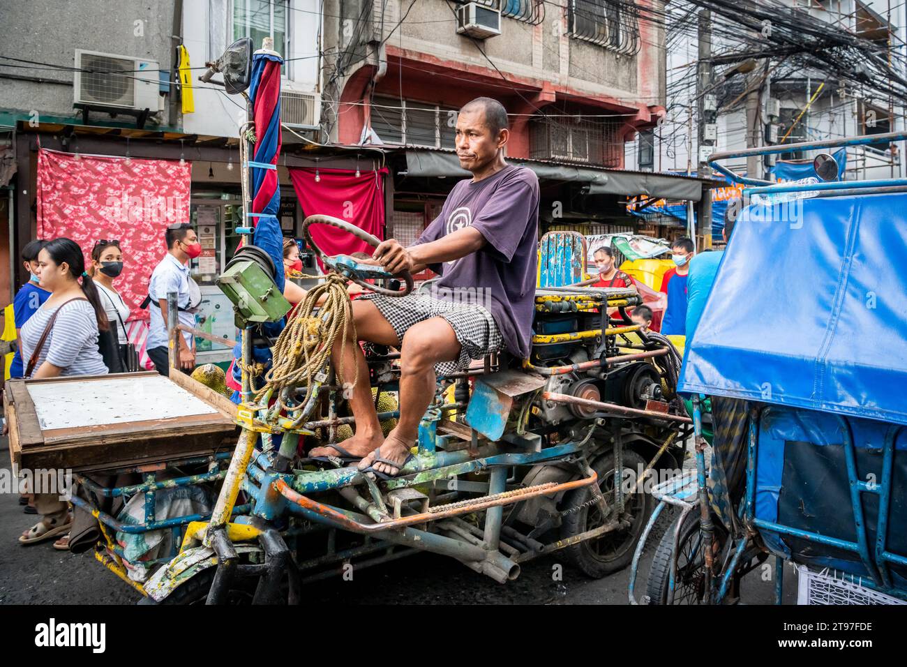 A Filipino worker make a delivery of goods on a tractor style truck in ...