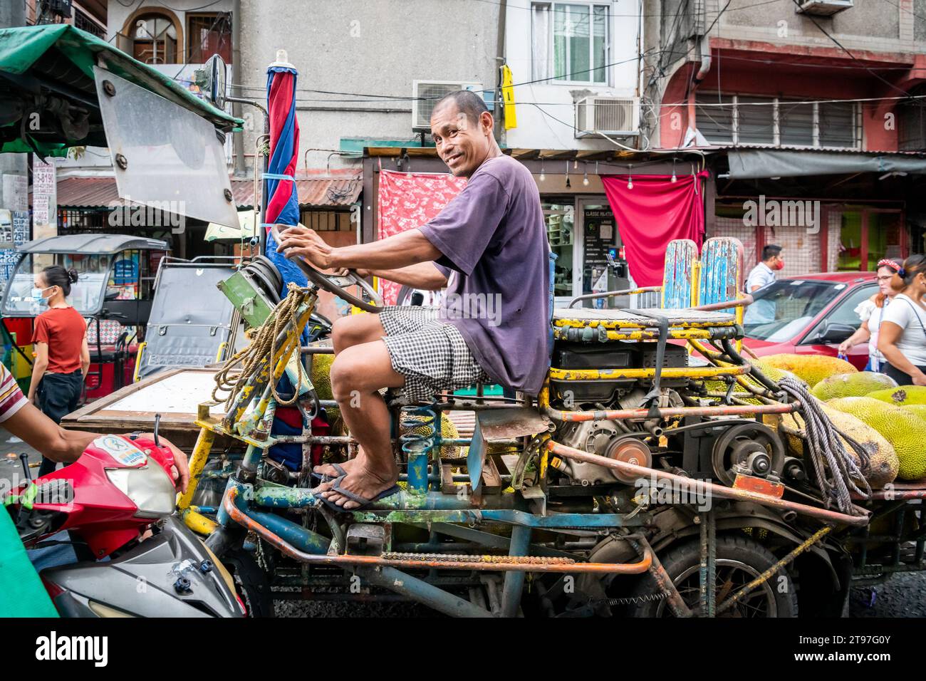 A Filipino worker make a delivery of goods on a tractor style truck in ...