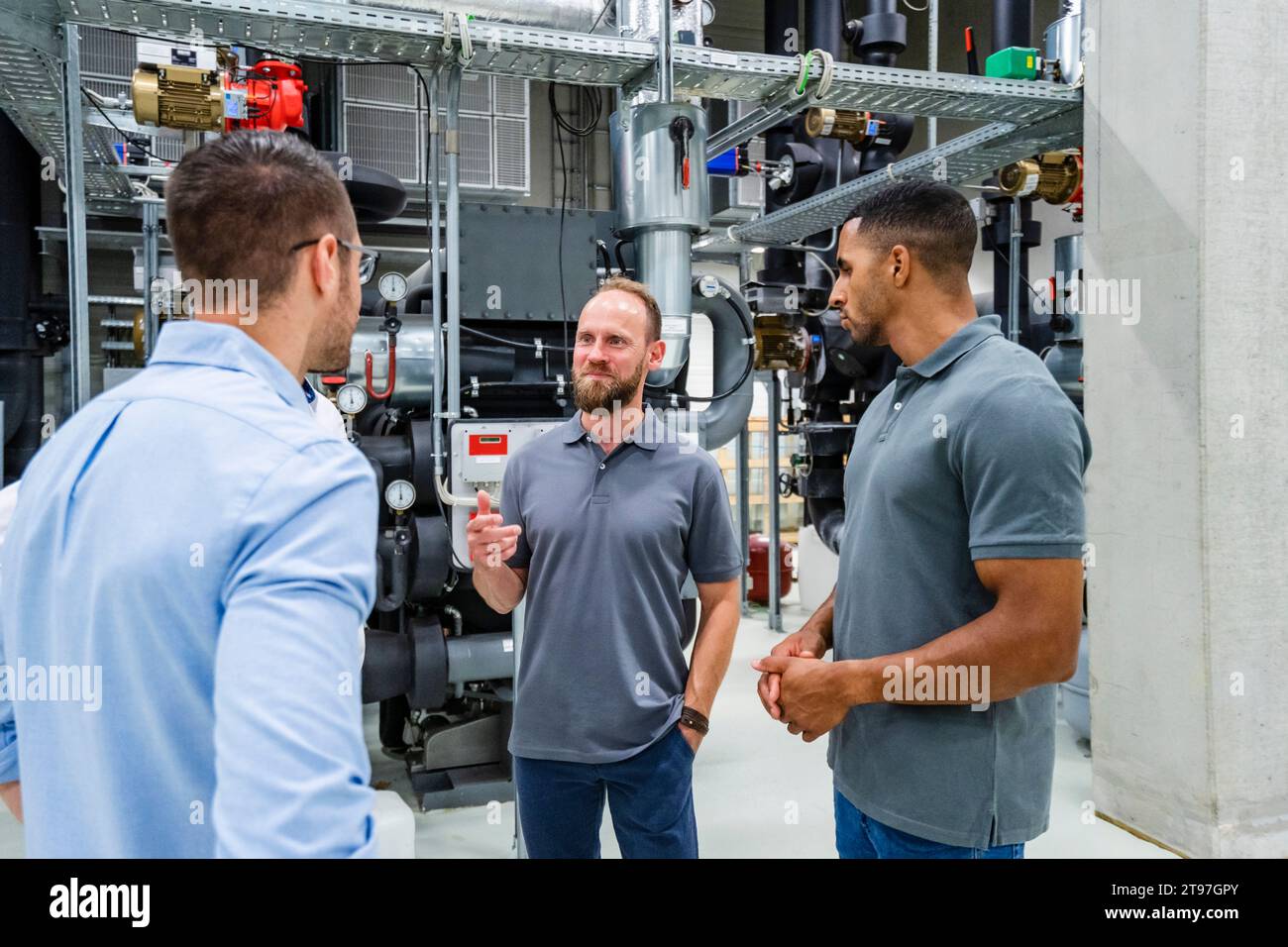 Businessman and employees having a meeting in factory Stock Photo - Alamy