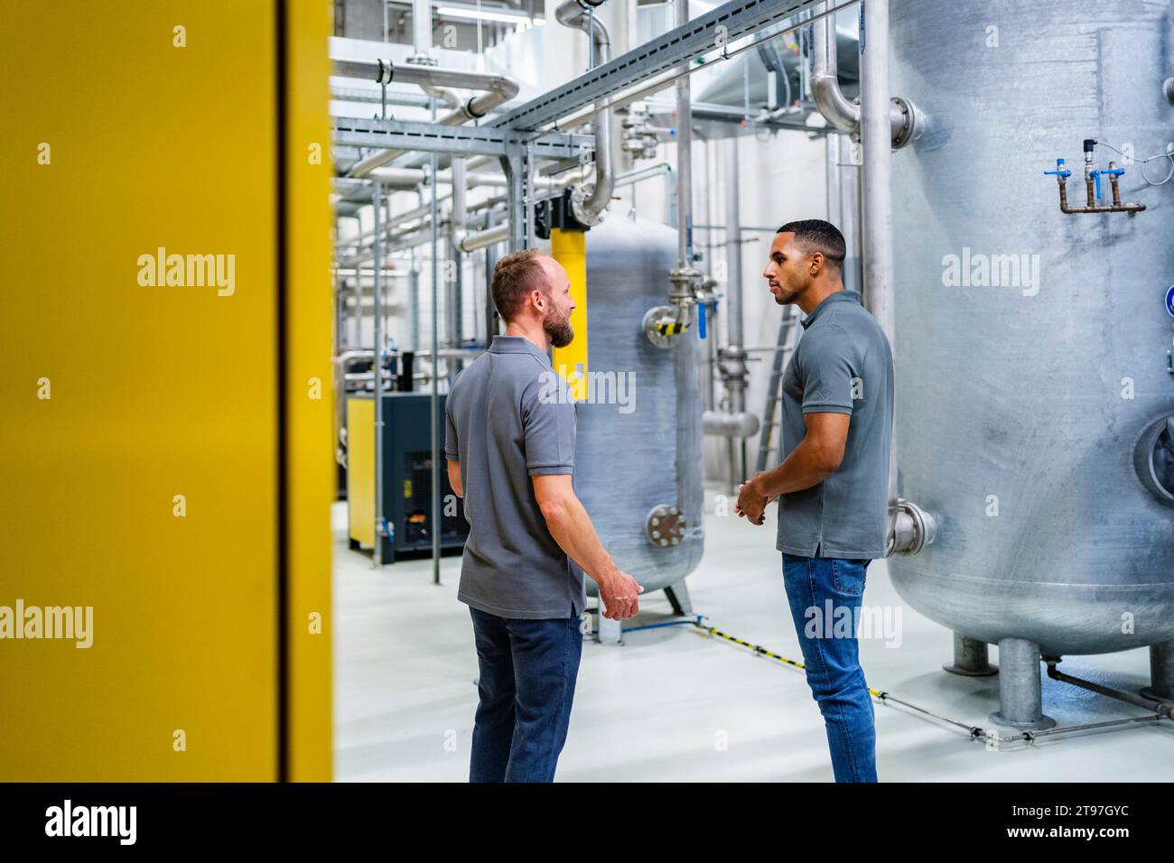 Two employees talking in factory Stock Photo - Alamy