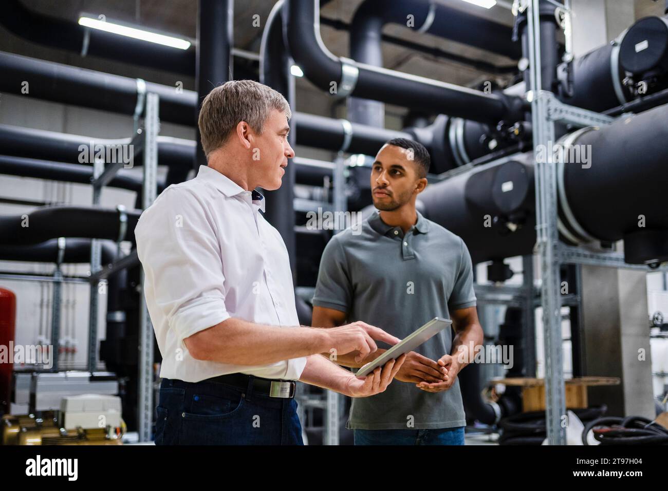 Employee and businessman with digital tablet talking in factory Stock ...